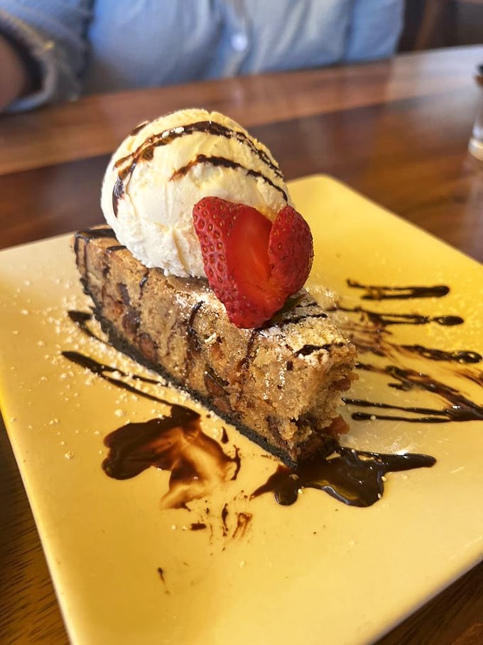 A slice of heaven anchored by vanilla ice cream and a strawberry sentinel—dessert architecture at its most delicious.