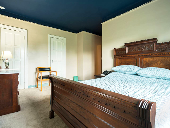 This bedroom's ornate wooden headboard tells stories of craftsmanship from another era&mdash;like sleeping in a museum, but cozier.