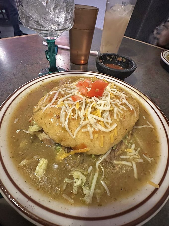That's not just any stuffed sopapilla—it's a golden pocket of possibility swimming in green chile sauce and topped with melty cheese.