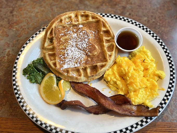 A waffle that's achieved the perfect golden-brown tan, flanked by eggs and bacon like loyal courtiers attending breakfast royalty.