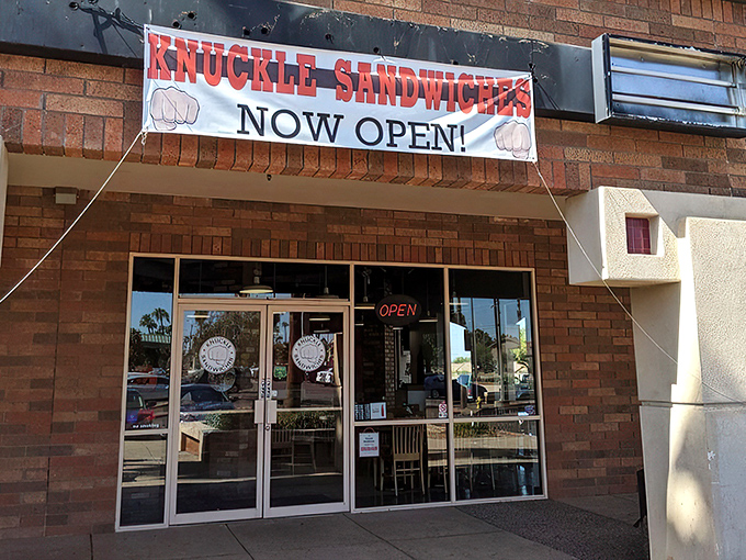 The "NOW OPEN!" banner might be outdated, but the promise of what awaits behind those brick walls is eternally fresh. A sandwich sanctuary beckons.