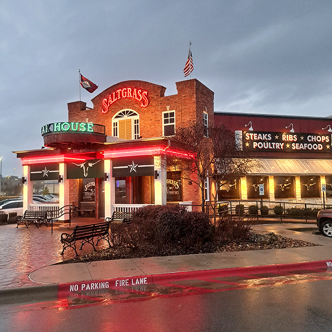 The brick facade of Saltgrass stands like a beacon of hope for hungry travelers. Those flags aren't just decoration&mdash;they're dinner semaphore.