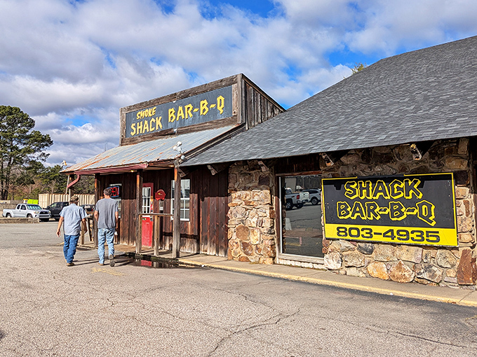 That hand-painted yellow sign against weathered wood isn't just decoration—it's a promise of smoky delights waiting behind that bright red door.