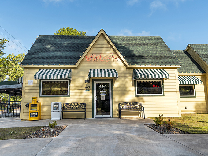 The cheerful yellow exterior of Stoby's with its iconic striped awnings stands like a beacon of comfort food promise in Conway.
