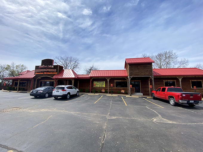 The red-roofed wooden exterior of Smokin' Joe's stands like a barbecue beacon in Rogers, promising smoky treasures within. A full parking lot never lies.