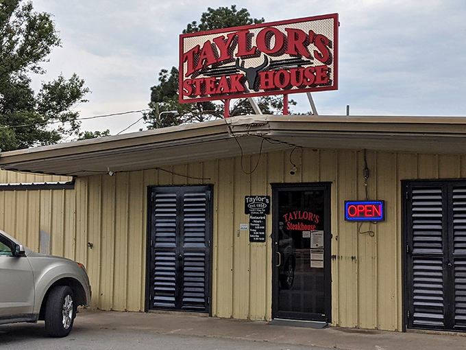 The unassuming exterior of Taylor's Steakhouse stands like a carnivore's lighthouse in Dumas, its iconic red sign promising meaty treasures within.
