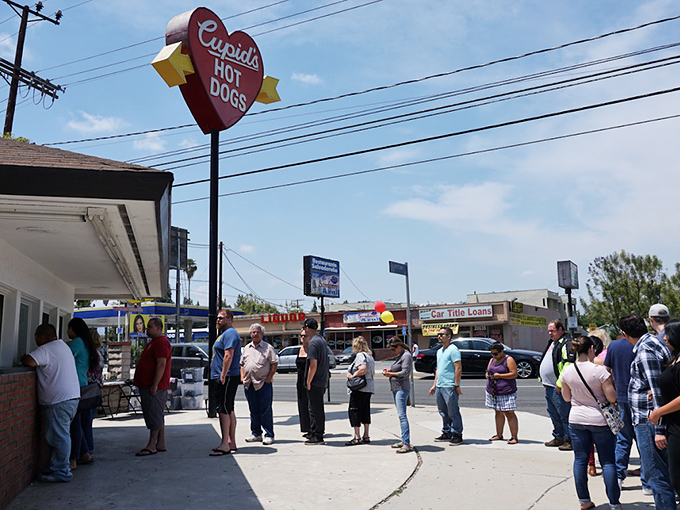 The iconic heart-shaped sign beckons hungry travelers like a culinary lighthouse. Cupid's modest exterior hides world-class hot dog magic within.