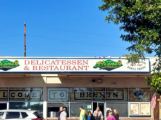The classic storefront of Brent's Deli beckons with its nostalgic charm. Those red umbrellas aren't just for show&mdash;they're gateways to sandwich paradise.