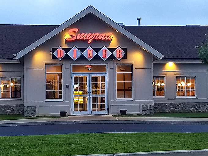 The iconic Smyrna Diner welcomes hungry travelers with its distinctive diamond-patterned sign and cozy stone facade. Delaware comfort food headquarters since the 1950s.