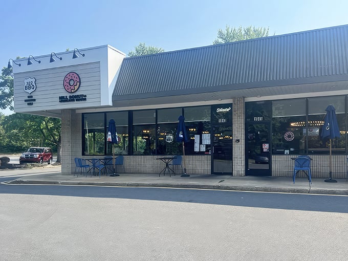 The pink donut sign beckons like a sugar-dusted lighthouse, guiding hungry travelers to this unassuming strip mall treasure in Wilmington.