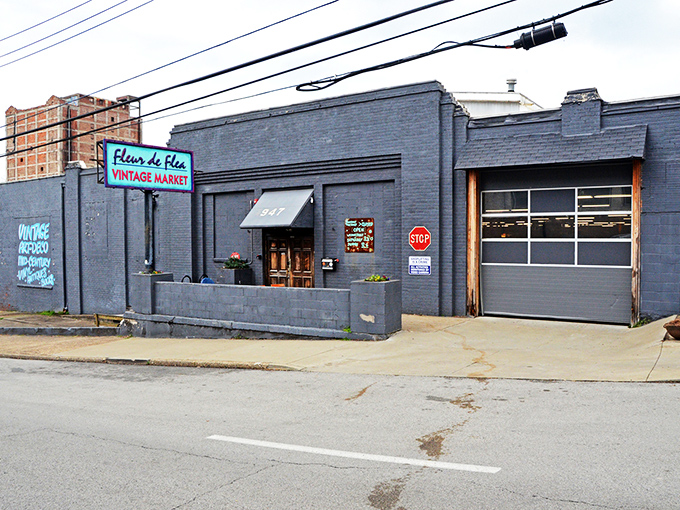 The turquoise sign beckons like a vintage siren song, promising treasures behind those brick walls that your modern big-box stores couldn't dream of housing.