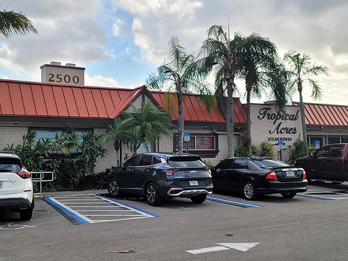 Tropical Acres stands like a time-honored oasis amid swaying palms, its iconic red roof and yellow walls promising culinary treasures within.