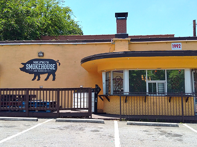 The unassuming beige fa&ccedil;ade with pink patio umbrellas says it all - true barbecue legends don't need fancy exteriors, just a good smoker and a pig sign.