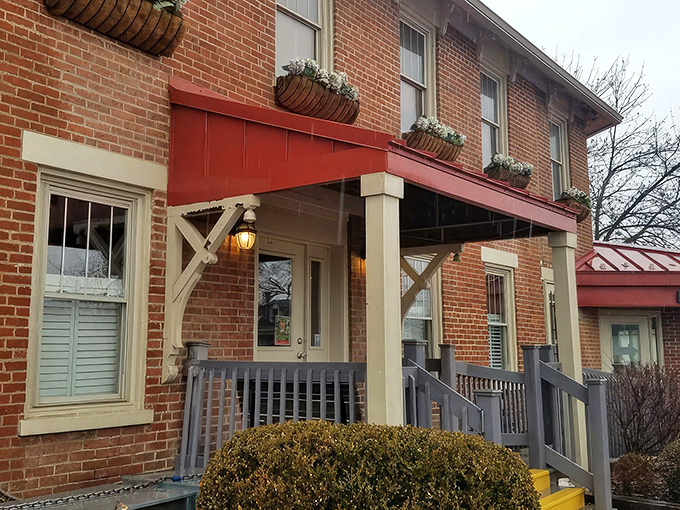The historic brick exterior of Old Canal Smoke House welcomes you with its charming red awning and flower boxes—like a barbecue beacon calling you home.