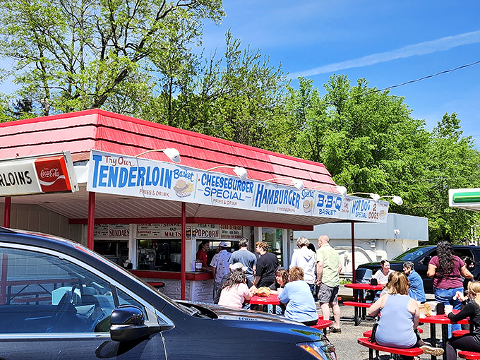 Lou's iconic red-roofed stand beckons like a neon-lit time machine, promising tenderloins and nostalgia in equal measure.