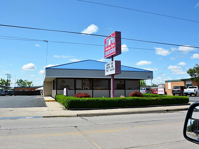 The unassuming blue-roofed building with its simple red sign might not scream "culinary destination," but locals know better. This modest exterior houses Kansas fried chicken royalty.