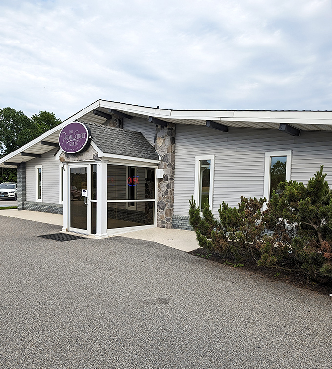 The neon pink sign glows like a beacon in the night, promising culinary treasures inside this unassuming roadside building.