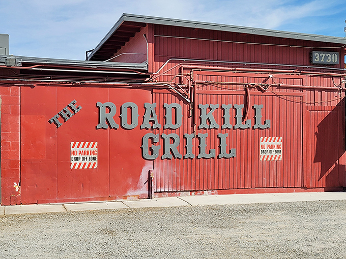 The bright red exterior of Road Kill Grill stands like a barbecue beacon in North Las Vegas, promising smoky delights within those unassuming walls.