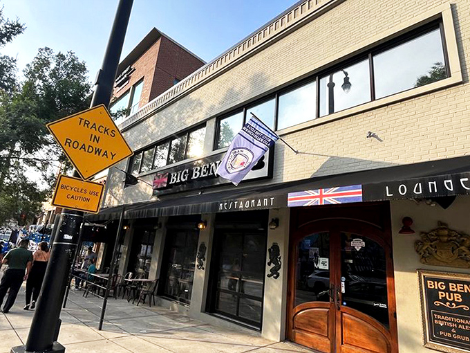 The Union Jack proudly announces your arrival at Big Ben Pub, where those magnificent wooden doors might as well be a portal straight to London.