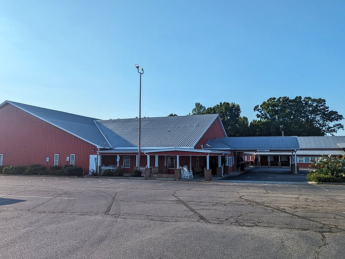 The iconic red barn exterior of Homestead Steakhouse stands proudly against Carolina blue skies, promising carnivorous delights within its unassuming walls.