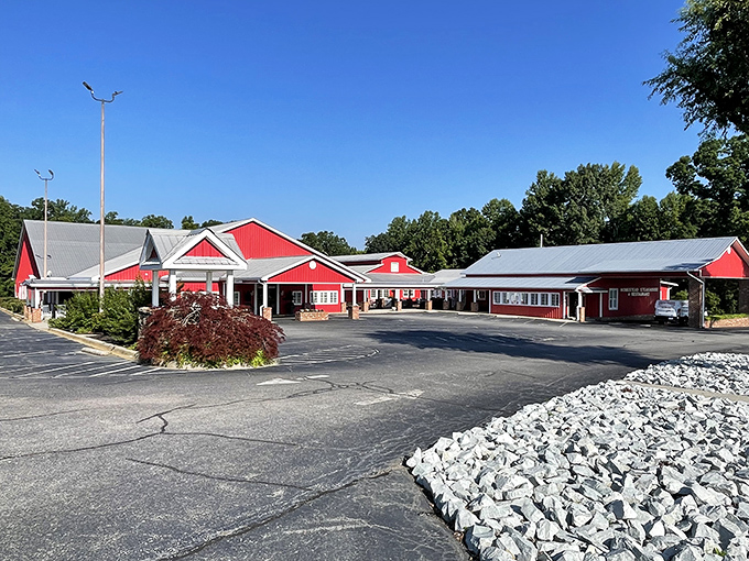 The iconic red barn exterior of Homestead Steakhouse stands proudly against Carolina blue skies, promising carnivorous delights within its unassuming walls.