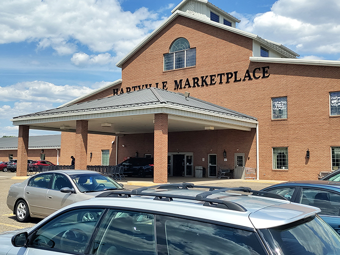 The brick facade of Hartville MarketPlace stands like a retail cathedral, promising treasures within. Even the parking lot buzzes with anticipation.