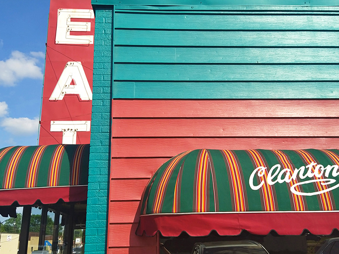 The vibrant turquoise and red exterior of Clanton's Café stands as a colorful beacon on Route 66, promising comfort food treasures within those striped awnings.