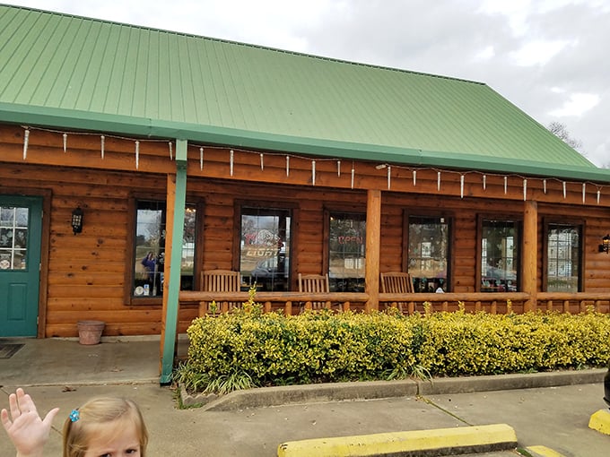 The rustic log cabin exterior of The Oaks isn't trying to impress you&mdash;until you taste what's cooking inside. Green roof, wooden benches, and promises of carnivorous delight await.