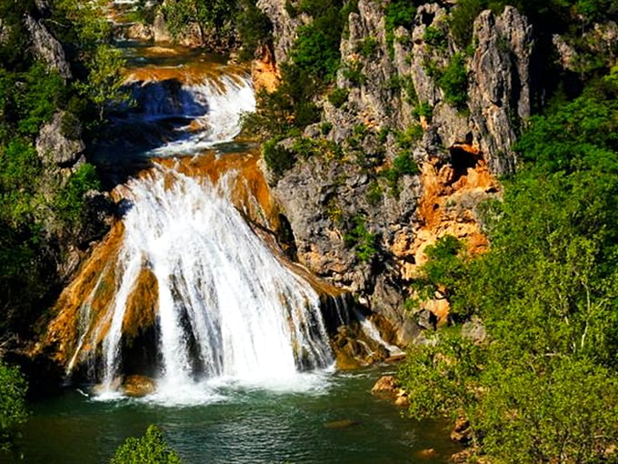 Nature's grand reveal: Turner Falls cascades 77 feet into a turquoise pool that looks like someone smuggled a piece of the Caribbean into Oklahoma. 