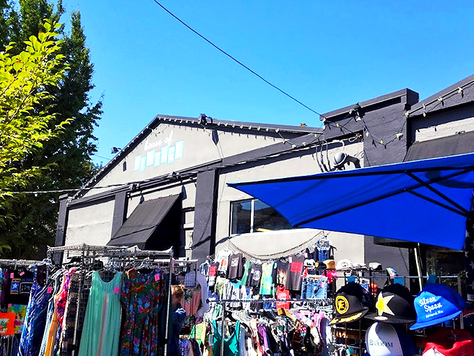 The unassuming storefront of House of Vintage beckons with colorful clothing racks outside, like a portal to decades past waiting to be explored.