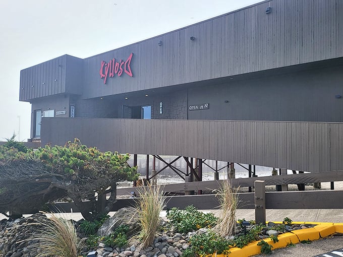 Kyllo's distinctive exterior stands like a modern lighthouse above the beach, beckoning hungry travelers with its glowing red sign.