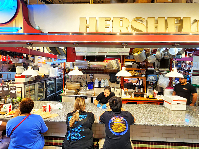 The neon "Deli" sign glows like a beacon of hope for the hungry. At Hershel's counter, sandwich artisans transform simple ingredients into edible masterpieces.