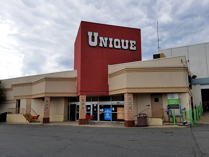The iconic red facade of Unique Thrift Store stands like a beacon of bargain possibilities in Falls Church, promising treasures within those sliding glass doors.
