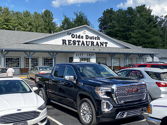 Welcome to comfort food paradise! The blue-sided exterior of Olde Dutch Restaurant in Logan invites hungry travelers with its charming porch and promise of home-cooked delights.