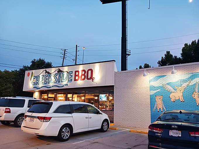 The blue and red Creekside BBQ sign beckons like a lighthouse for the hungry, promising smoky treasures inside this Pelham landmark. 