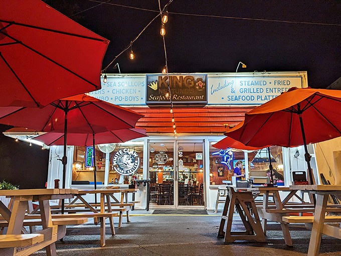 The unassuming exterior of King Neptune's hides culinary treasures within. Those red umbrellas aren't just for show—they're beacons for seafood lovers.
