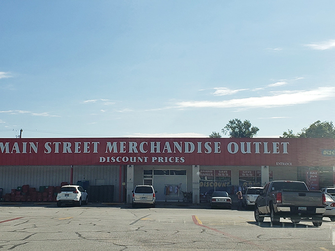 The bright red exterior of Main Street Merchandise Outlet practically shouts "bargains inside!" like a carnival barker with actual deals to offer.