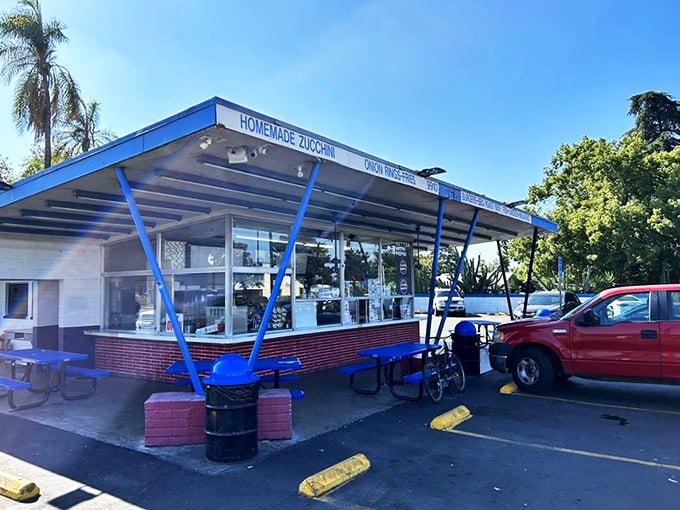 The blue-striped awning of George's Drive-In stands like a beacon of burger paradise against the California sky, promising delicious nostalgia with every order.