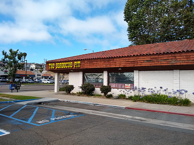 The unassuming exterior of The Barbecue Pit stands like a beacon of hope for hungry travelers. That yellow sign promises smoky salvation within those humble walls.