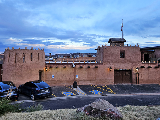 The Fort's adobe entrance glows with warmth against the night sky, luminous farolitos beckoning hungry travelers to step back in time at 6,100 feet elevation.