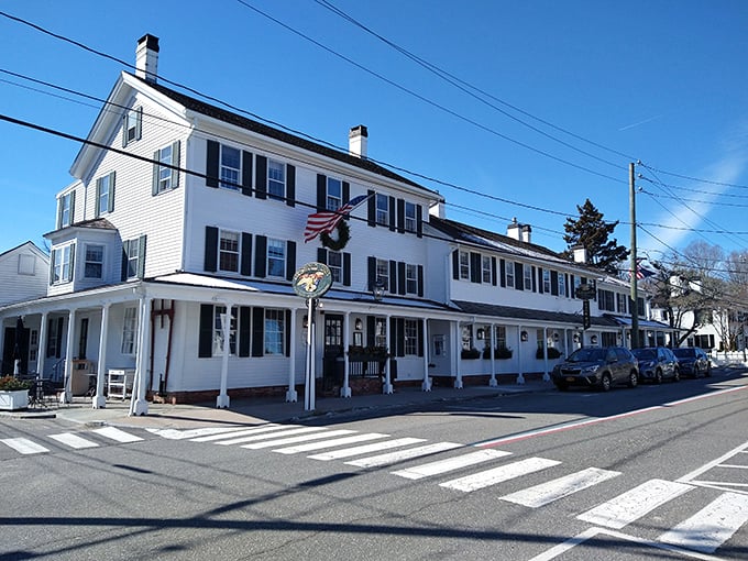 The white clapboard exterior of The Griswold Inn stands proudly in Essex, its patriotic bunting and antique wagon announcing: history happened here, and it was delicious.