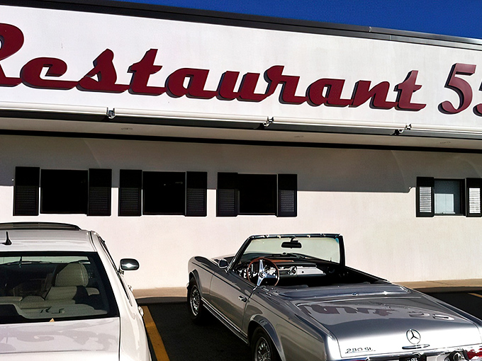 The classic red script signage welcomes you like an old friend. That vintage Mercedes in the parking lot suggests you're not the only one with good taste.