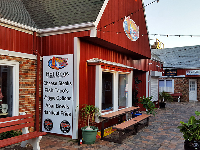 The iconic red barn exterior of Twilley's Willys stands like a beacon of hot dog hope against the Delaware sky, promising delicious adventures within.