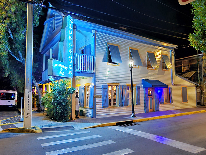 The iconic blue fence and hand-painted sign welcome you to Blue Heaven, where Key West's quirky spirit meets culinary paradise.