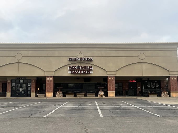 The neon sign of Six Mile Chop House beckons like a carnivore's lighthouse, promising safe harbor for the steak-obsessed traveler in Lawrence.