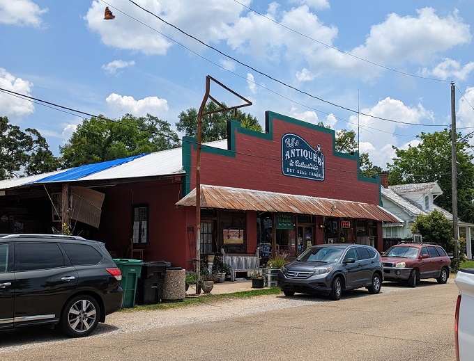 The vibrant red facade of C.J.'s Antiques & Collectibles stands out like a beacon for treasure hunters, promising adventures in nostalgia beneath that rustic metal roof.