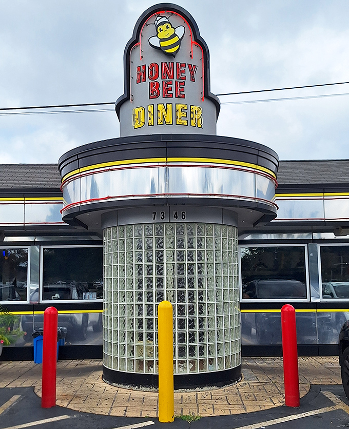 The classic mid-century diner silhouette of Honey Bee stands proud against the Maryland sky, its cheerful bee mascot promising sweet culinary delights within.