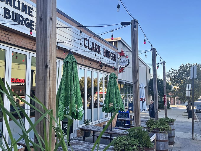 Clark Burger's inviting exterior welcomes hungry patrons with string lights and green umbrellas. It's like your favorite neighborhood joint got a stylish makeover.