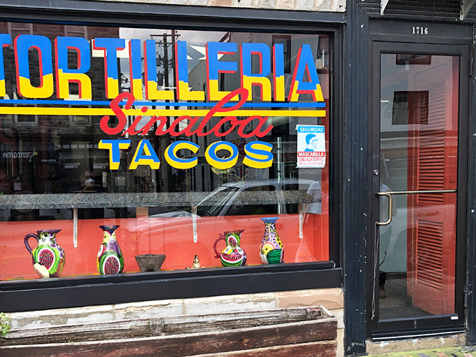 The storefront announces itself with vibrant blue, red, and yellow lettering that seems to say, "Yes, this is the real deal." Colorful ceramic pitchers in the window hint at the authenticity waiting inside.