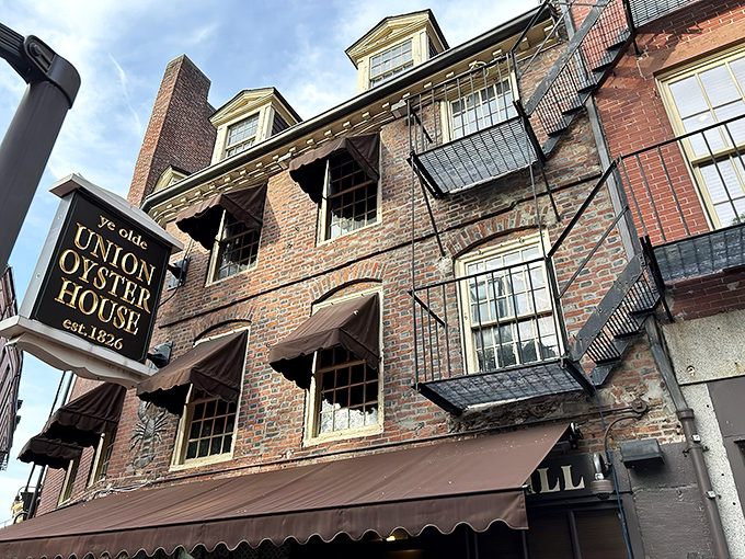The historic brick facade of Union Oyster House glows with welcome as night falls, a culinary lighthouse that has guided hungry Bostonians since 1826. 